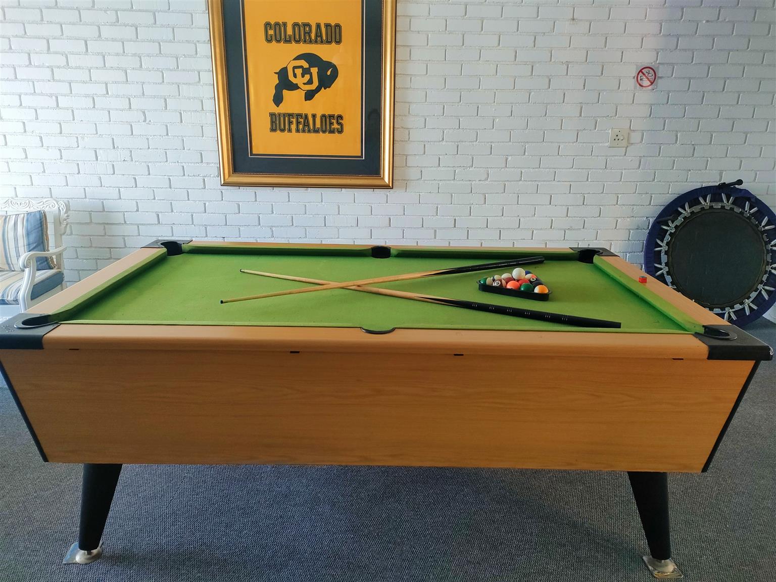 Solid oak pool table with green felt top.Two cues and cue stick holder ...