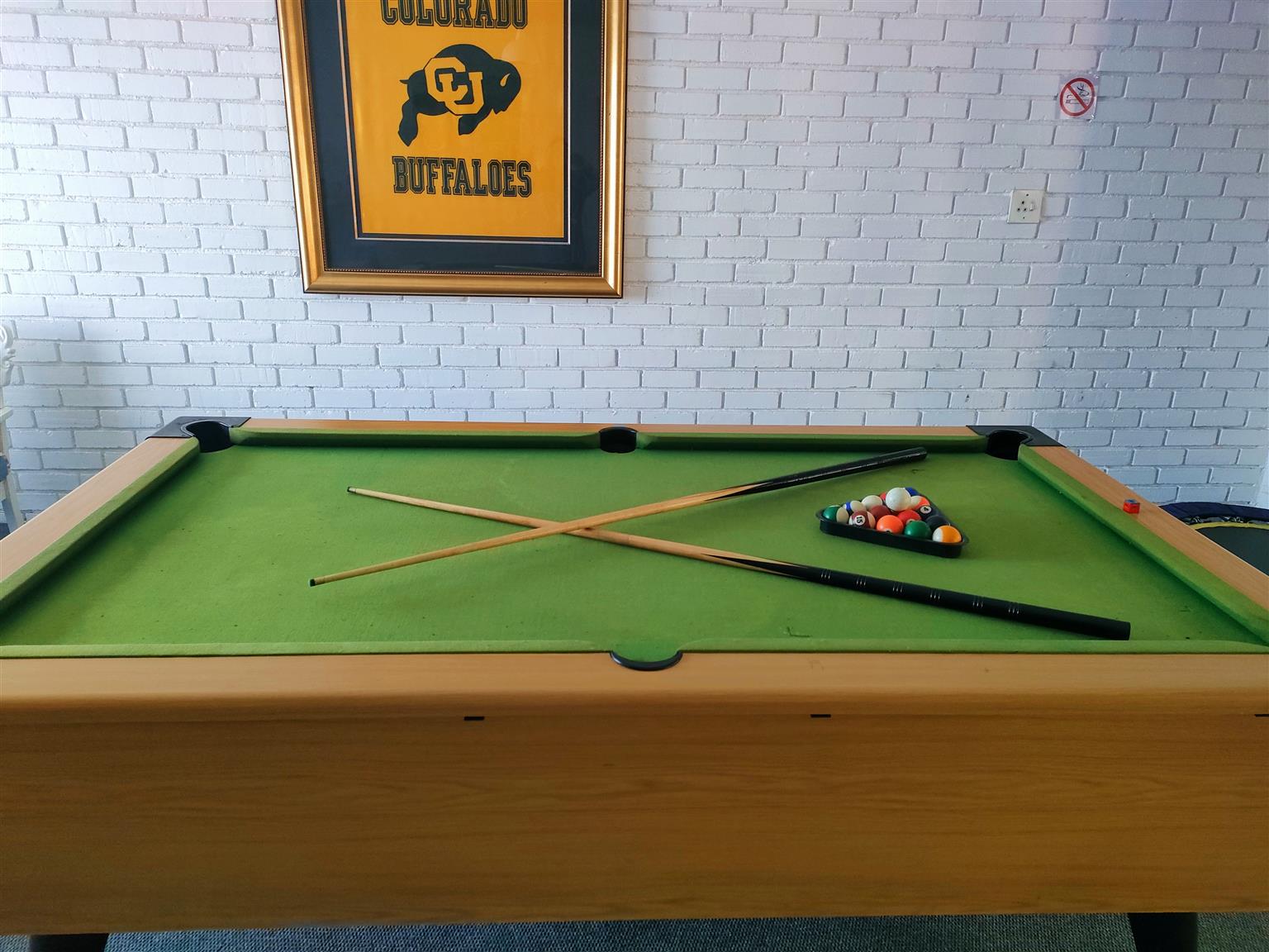 Solid oak pool table with green felt top.Two cues and cue stick holder ...